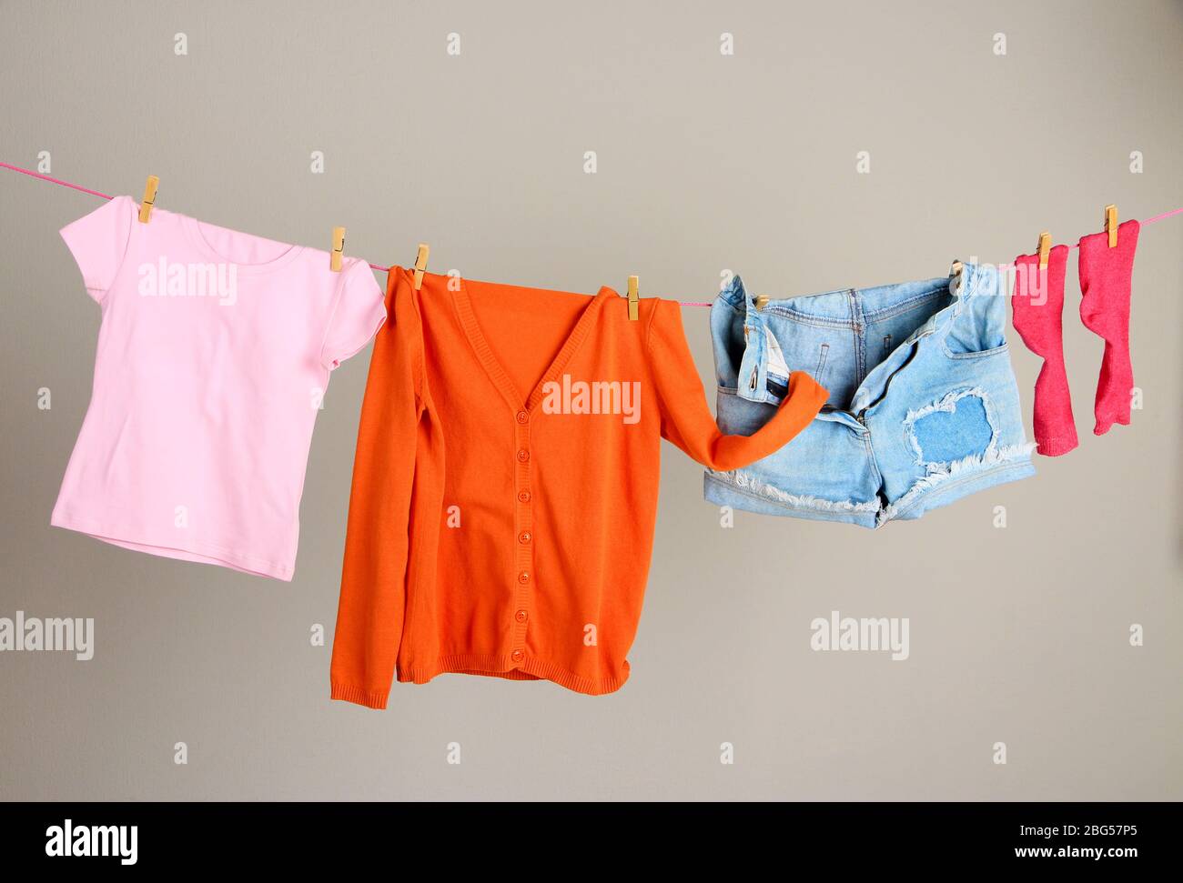 Laundry line with clothes on wall background Stock Photo - Alamy