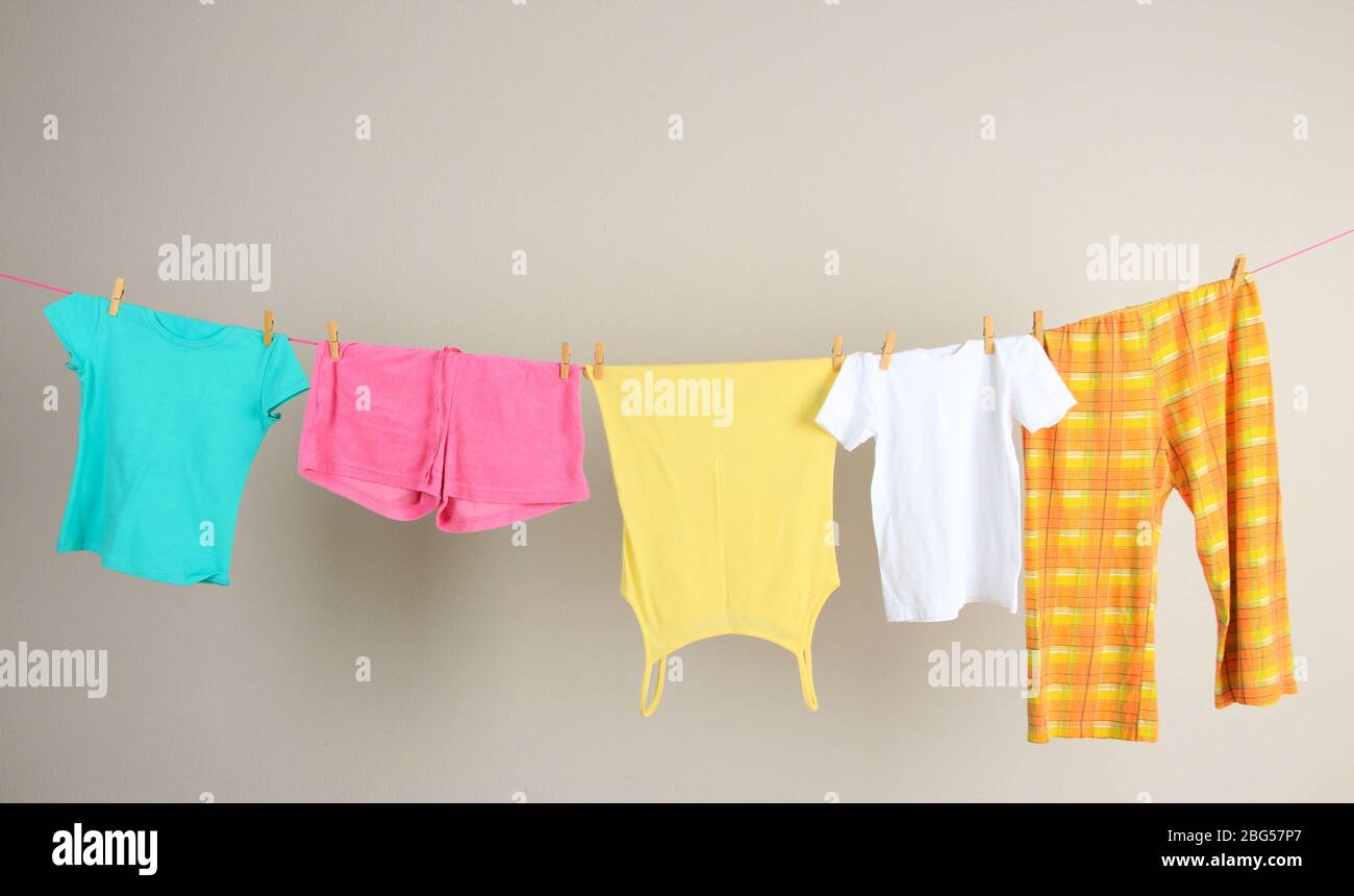 Laundry line with clothes on wall background Stock Photo - Alamy
