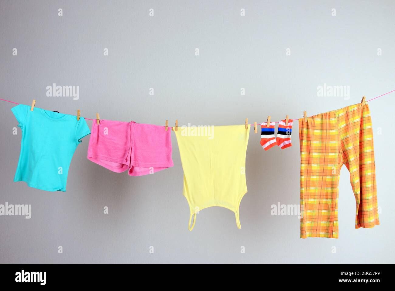 Laundry line with clothes on wall background Stock Photo - Alamy