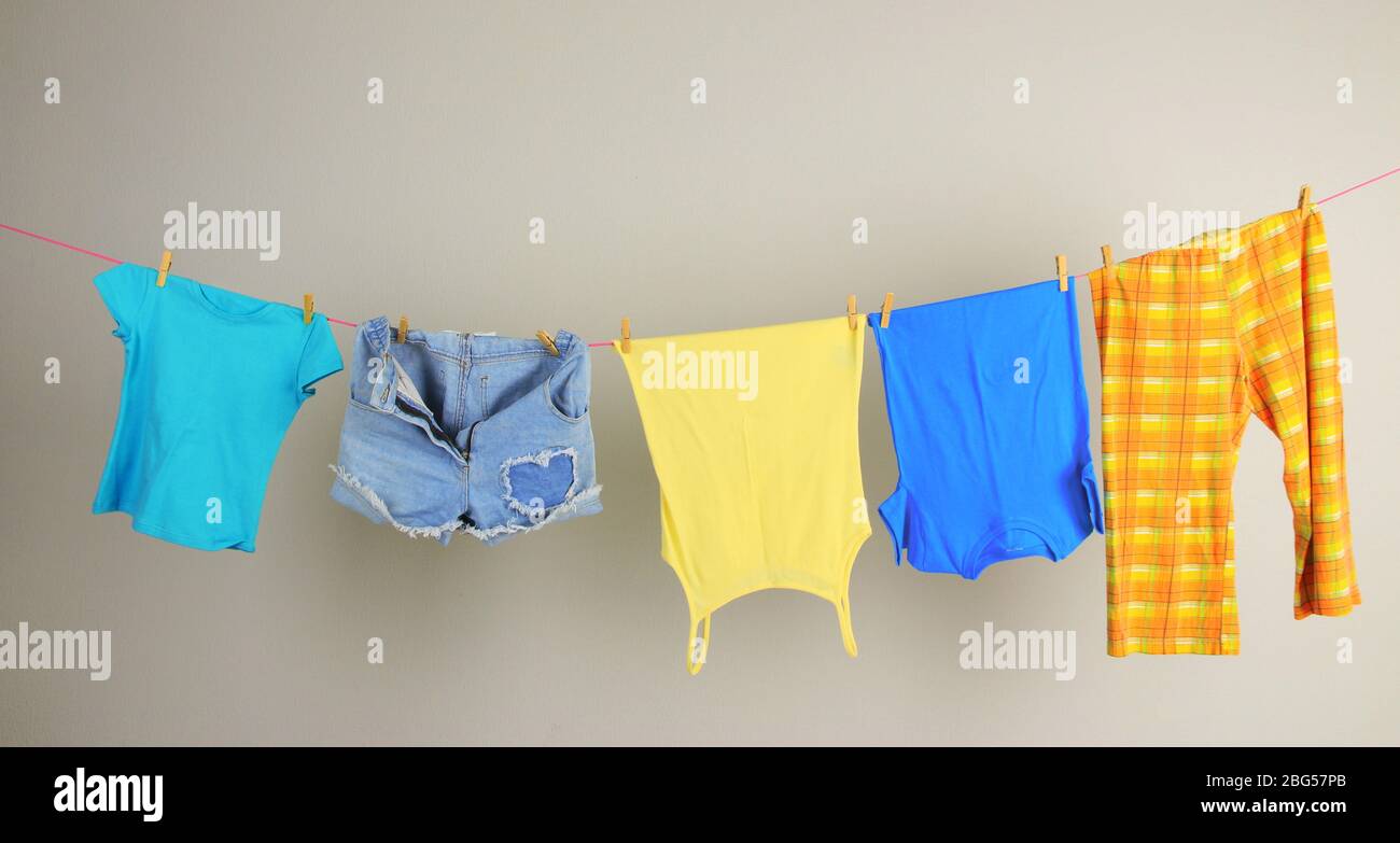 Laundry line with clothes on wall background Stock Photo - Alamy