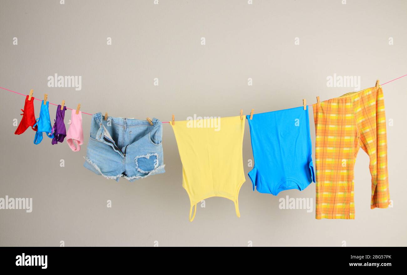 Laundry line with clothes on wall background Stock Photo - Alamy