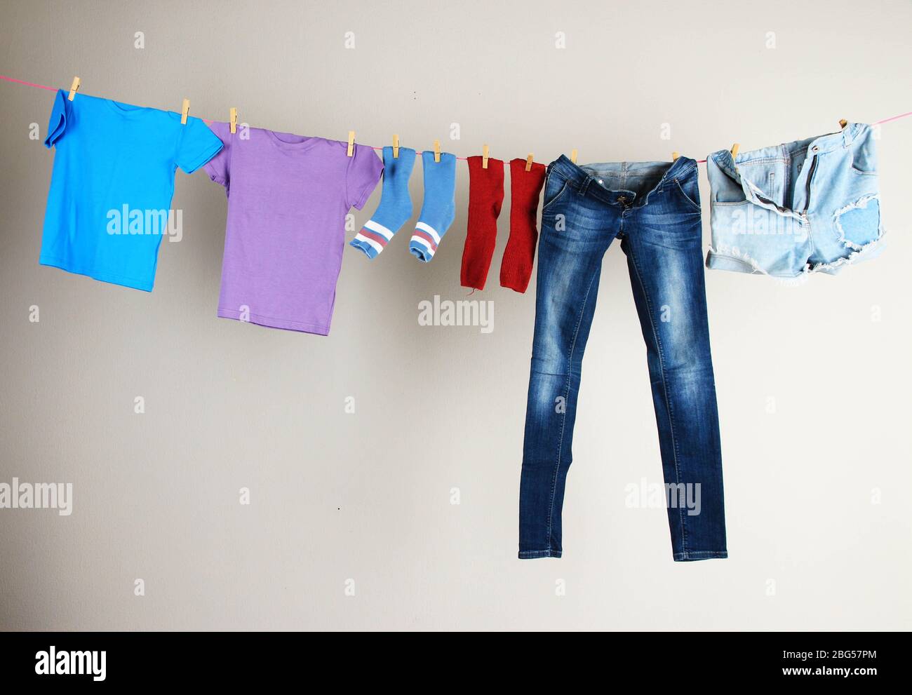 Laundry line with clothes on wall background Stock Photo - Alamy