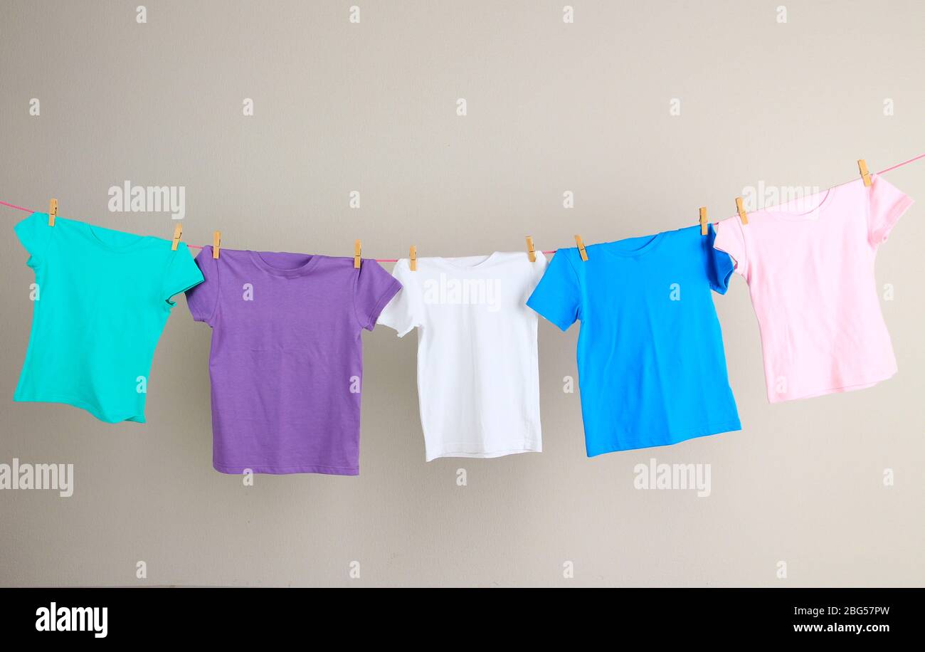 Laundry line with clothes on wall background Stock Photo - Alamy