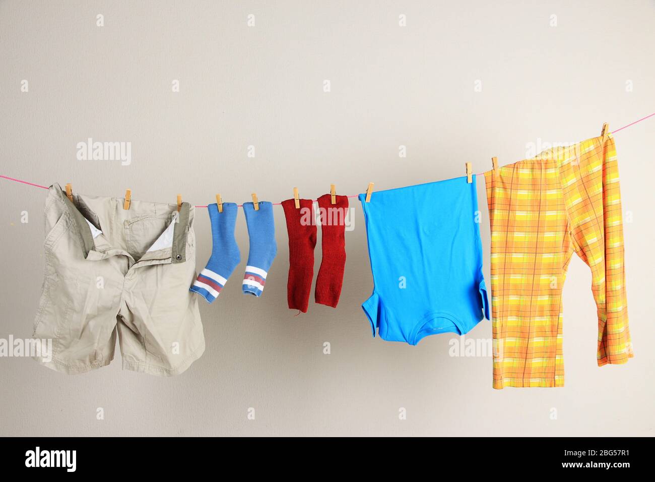 Laundry line with clothes on wall background Stock Photo - Alamy