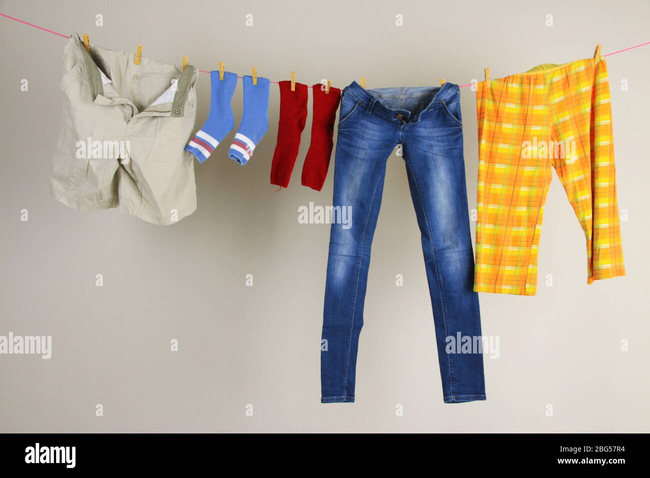 Laundry line with clothes on wall background Stock Photo - Alamy