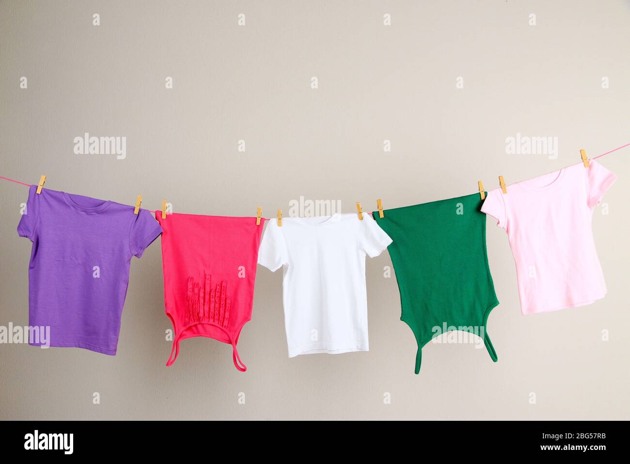 Laundry line with clothes on wall background Stock Photo - Alamy