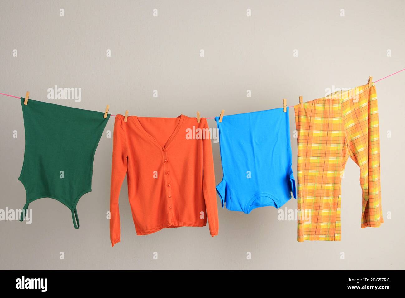 Laundry line with clothes on wall background Stock Photo - Alamy