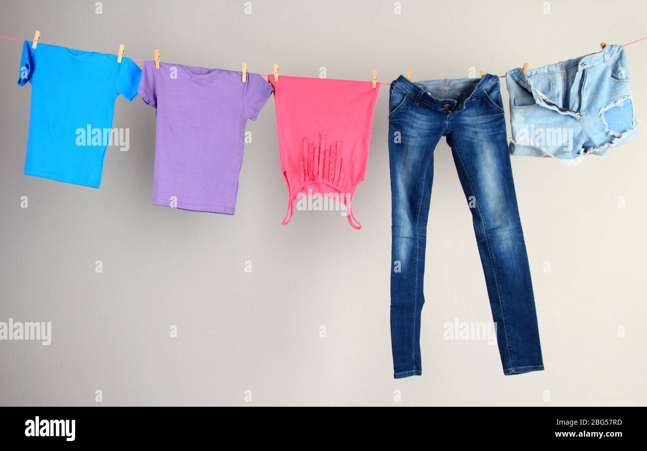 Laundry line with clothes on wall background Stock Photo - Alamy
