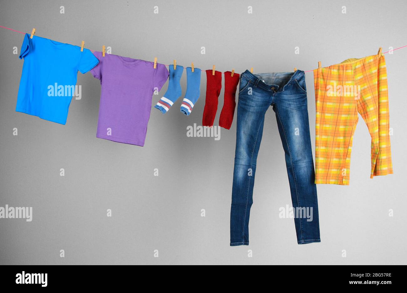 Laundry line with clothes on wall background Stock Photo - Alamy
