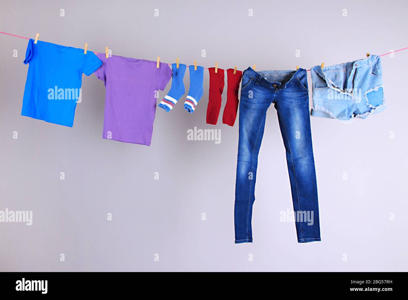 Laundry line with clothes on wall background Stock Photo - Alamy
