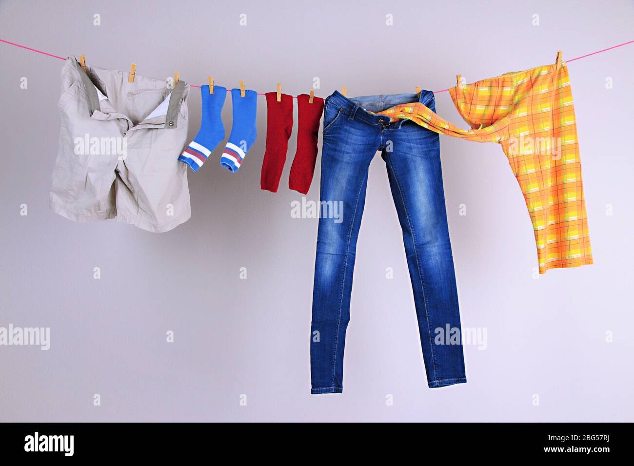 Laundry line with clothes on wall background Stock Photo - Alamy