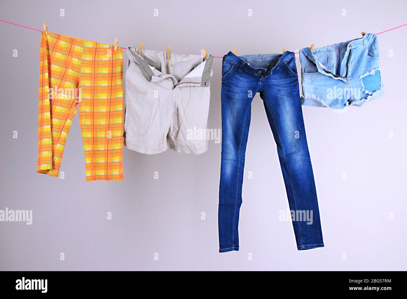 Laundry line with clothes on wall background Stock Photo - Alamy