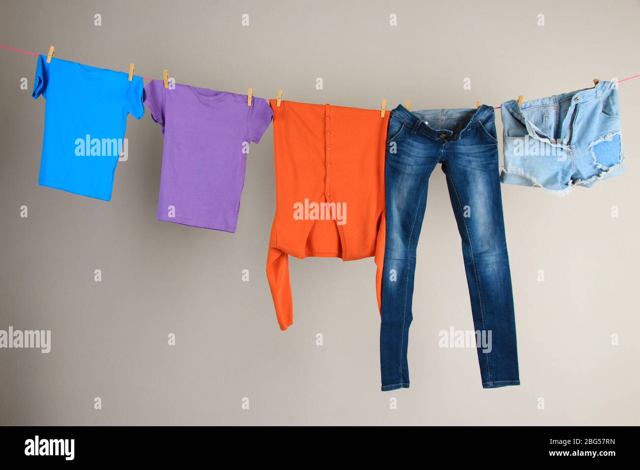 Laundry line with clothes on wall background Stock Photo - Alamy
