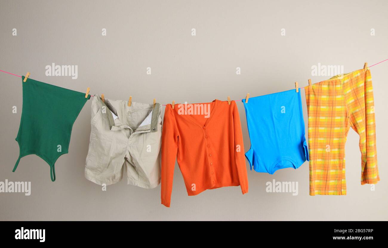 Laundry line with clothes on wall background Stock Photo - Alamy