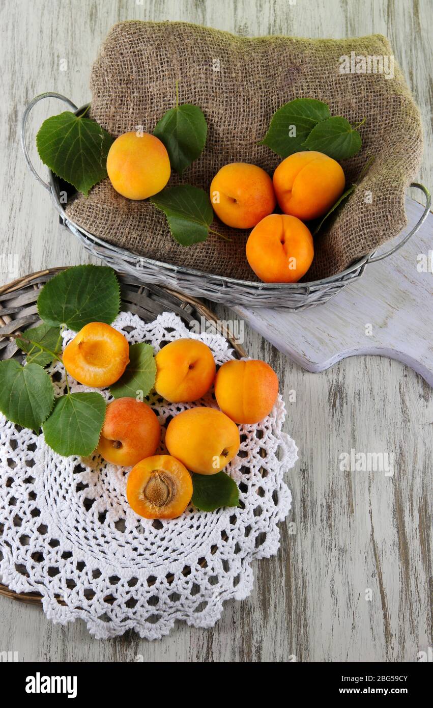Apricots in basket on napkin on wooden table Stock Photo - Alamy