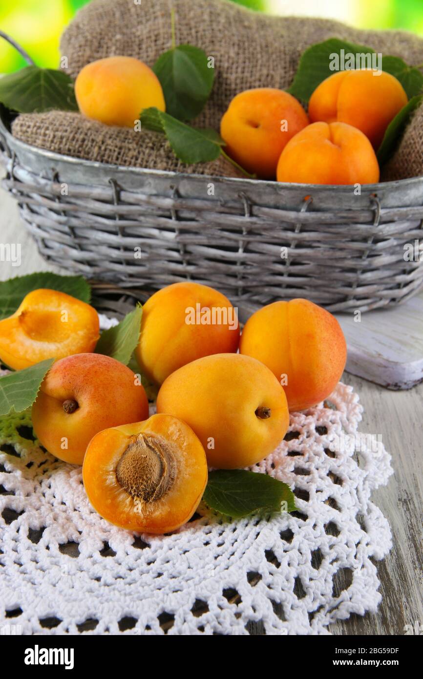 Apricots in basket on napkin on wooden table on nature background Stock ...