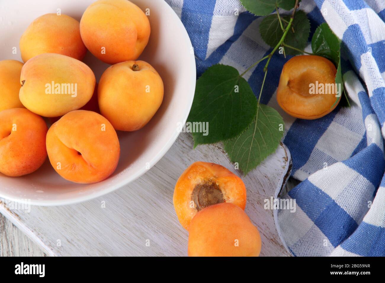 Apricots on board for cutting on napkin on wooden table Stock Photo - Alamy