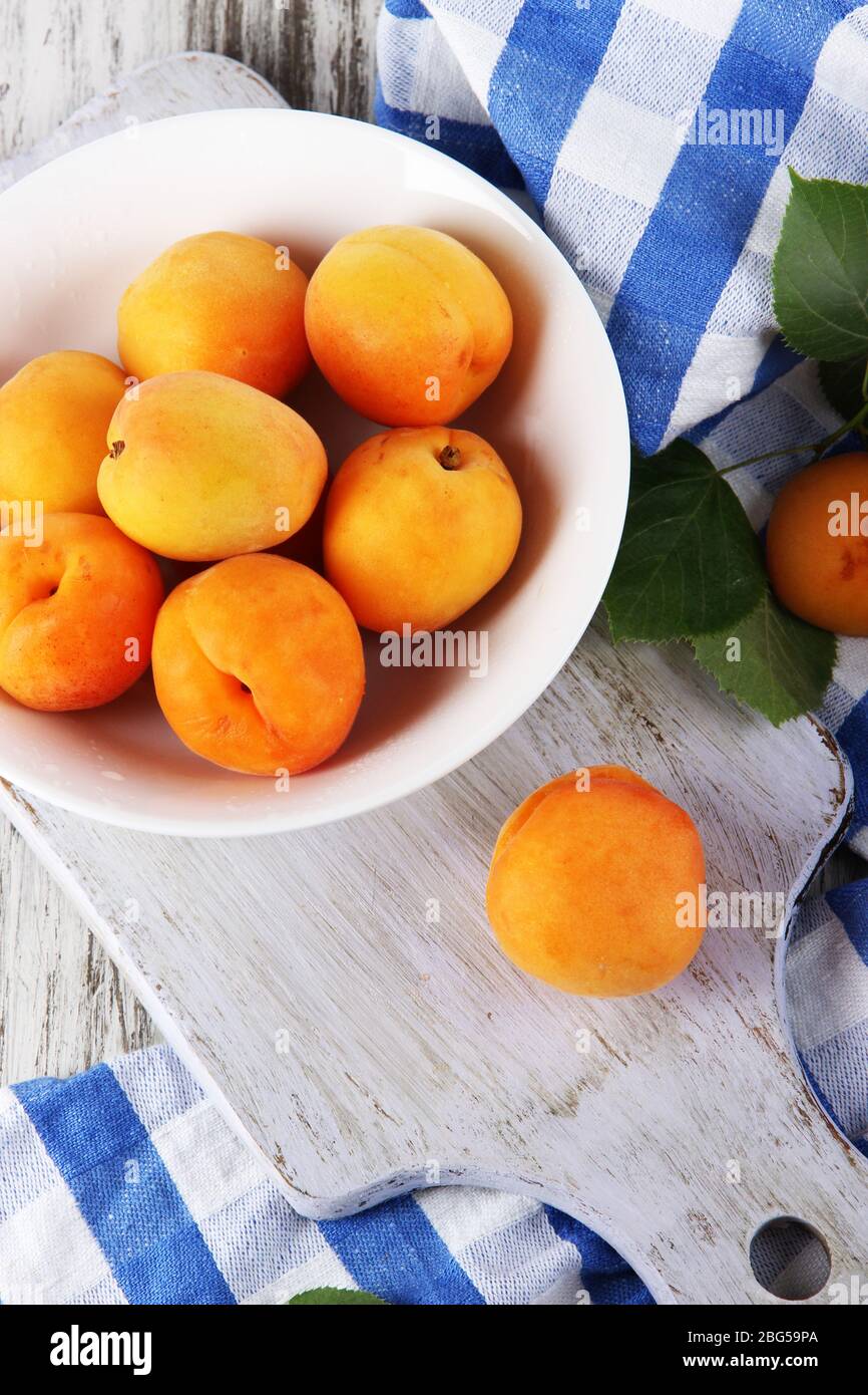 Apricots on board for cutting on napkin on wooden table Stock Photo - Alamy