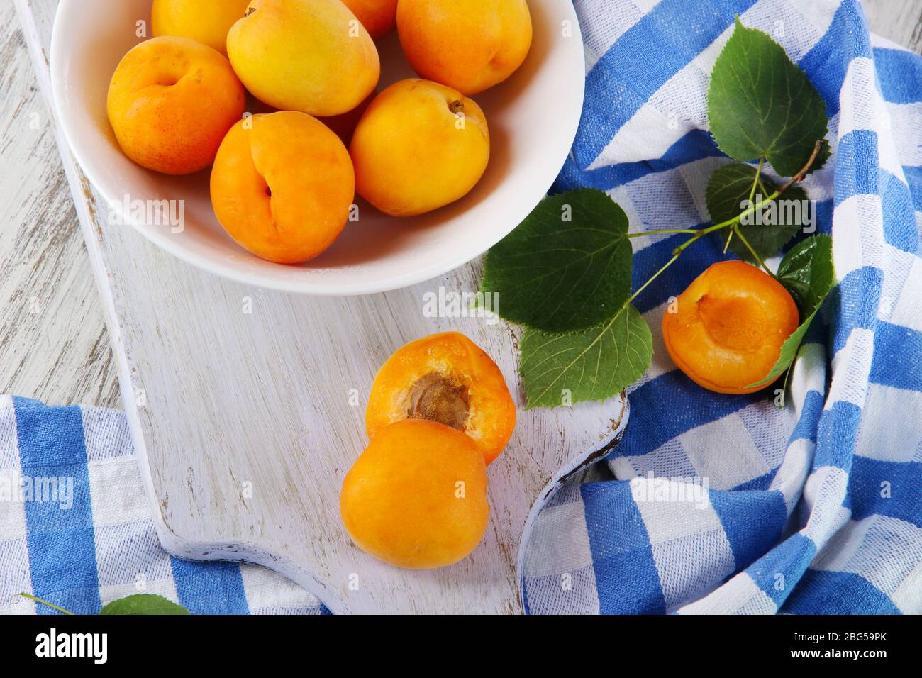 Apricots on board for cutting on napkin on wooden table Stock Photo - Alamy