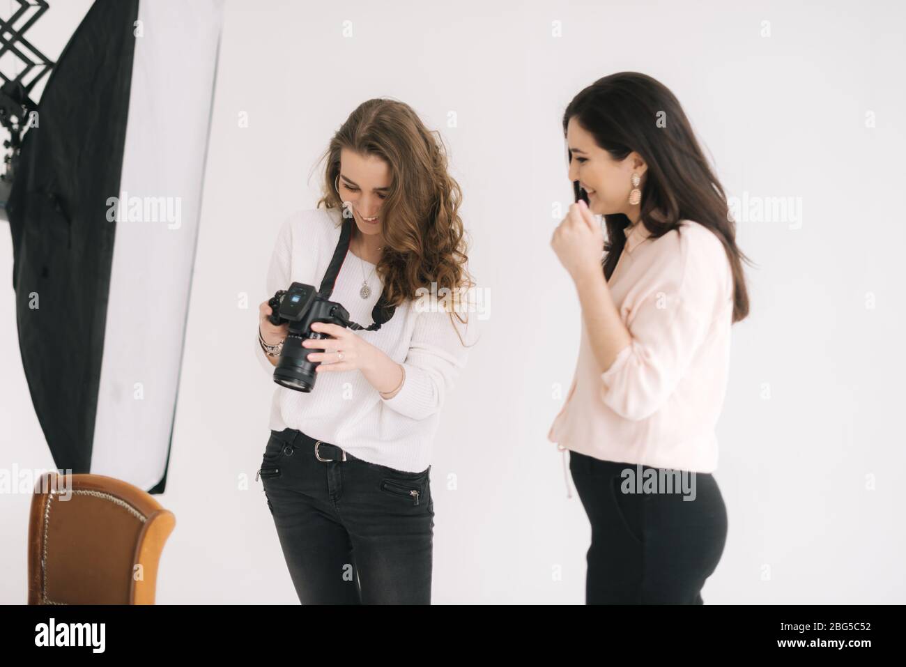 Woman photographer and female model together looking at made photo on ...