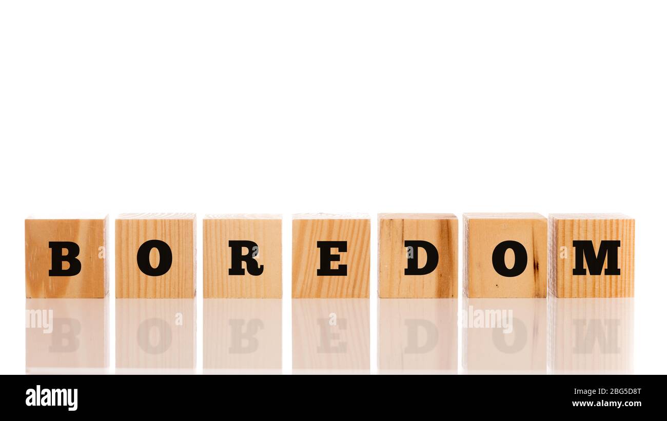 The word - Boredom- on wooden cubes arranged in a line on a reflective ...