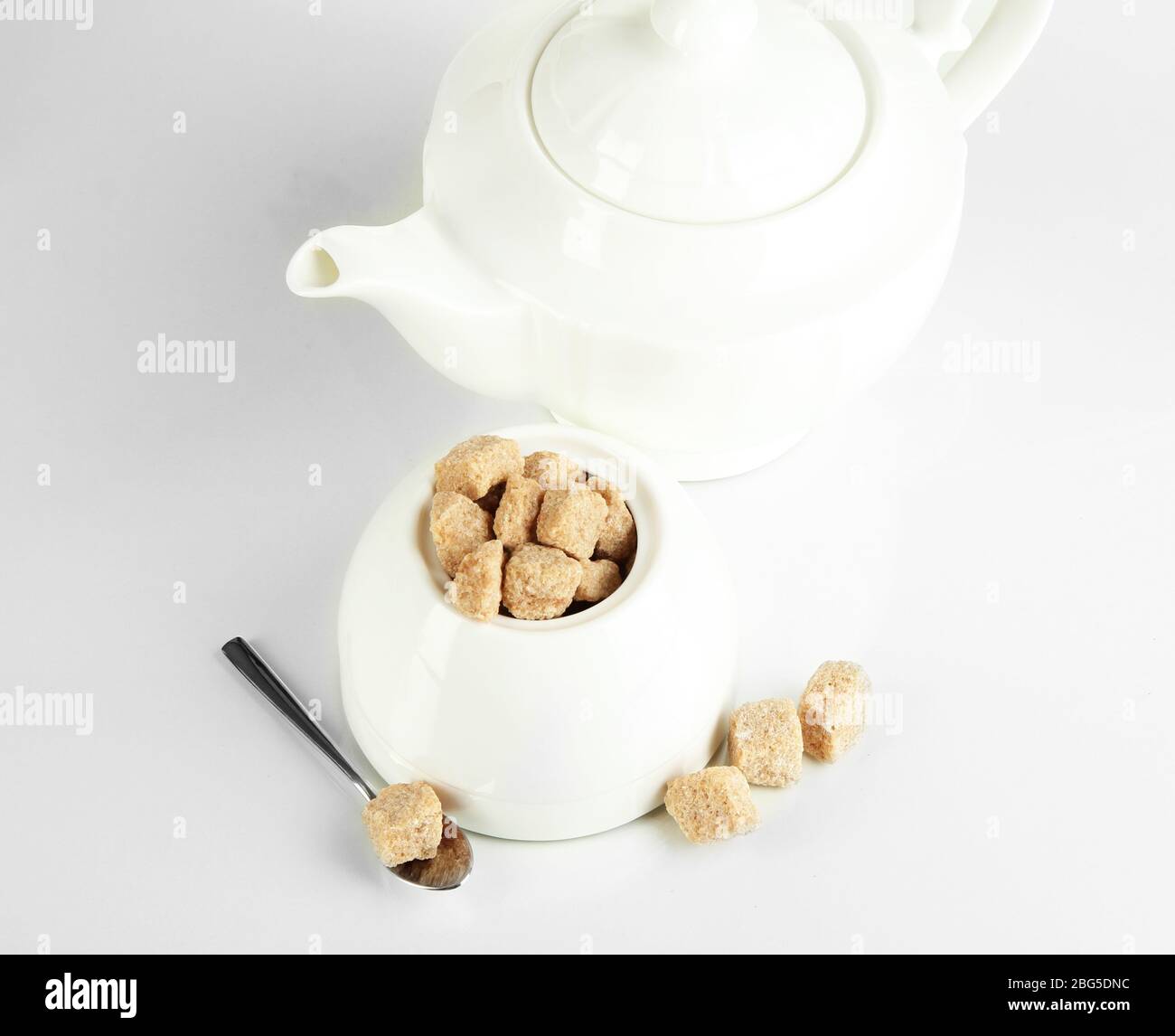 Unrefined sugar in white sugar bowl on grey background Stock Photo - Alamy