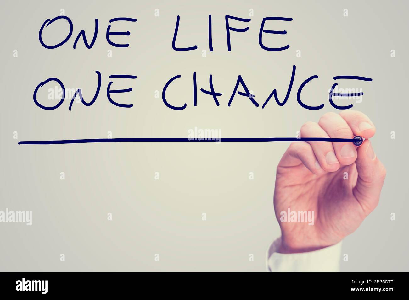 Retro instagram style image of a male hand writing phrase One life one ...