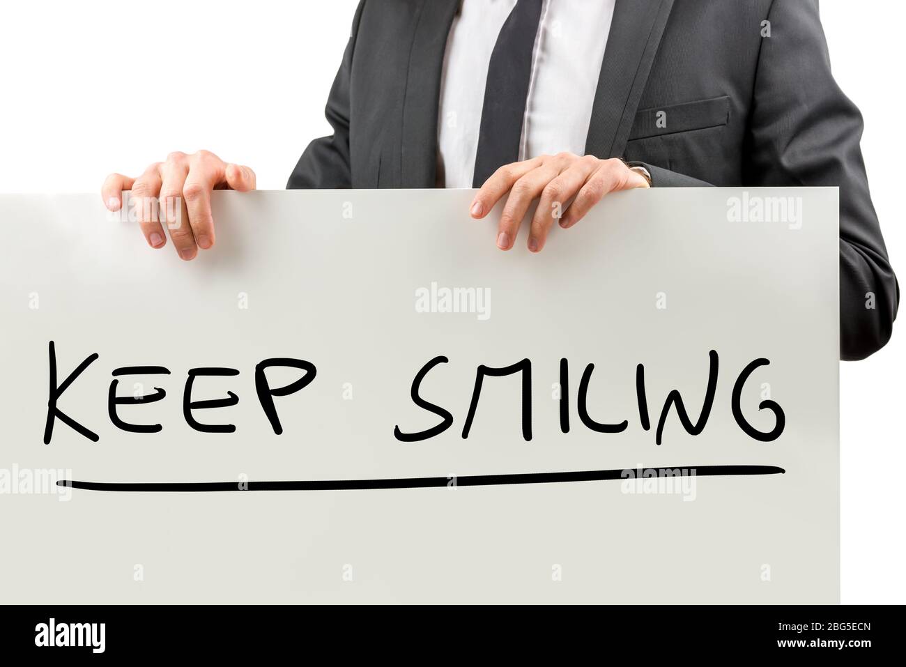 Man in an elegant suit holding white board with Keep smiling sign on it ...