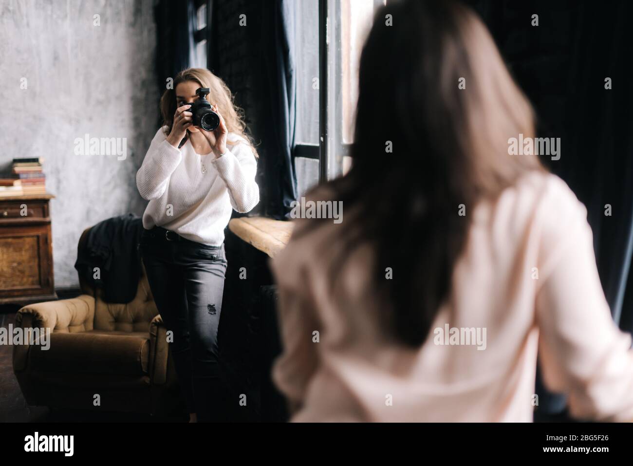 Back view of unrecognizable photographer working with beautiful young ...
