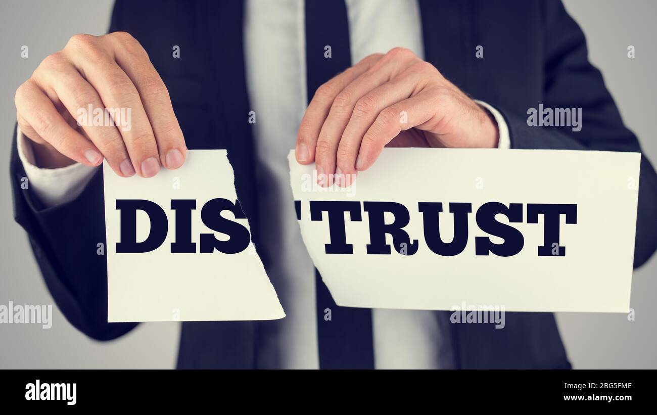 Businessman tearing up a sign saying - Distrust - conceptual image ...