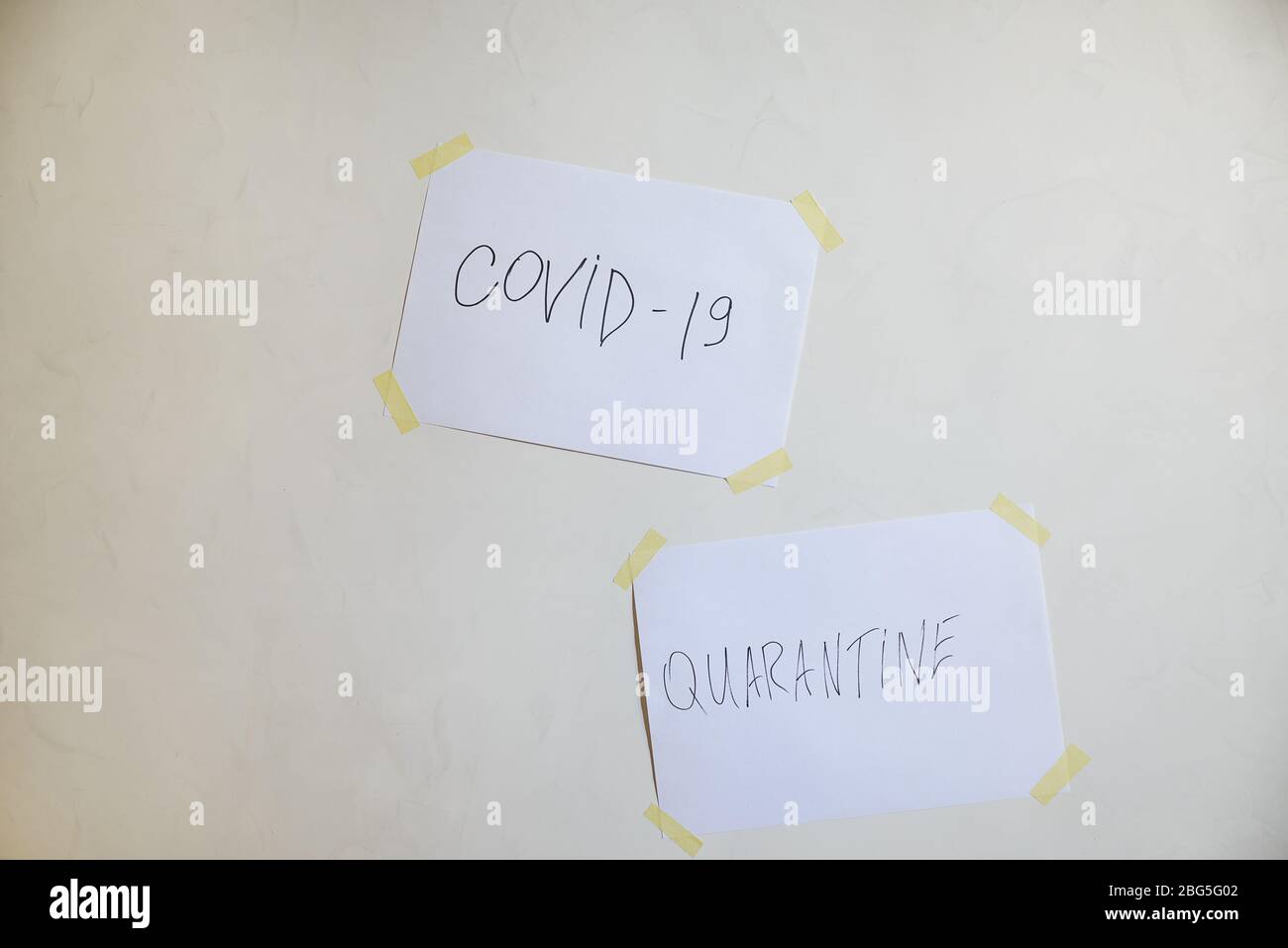 Two covid-19 labels and quarantine on a sheet glued to the wall. The ...