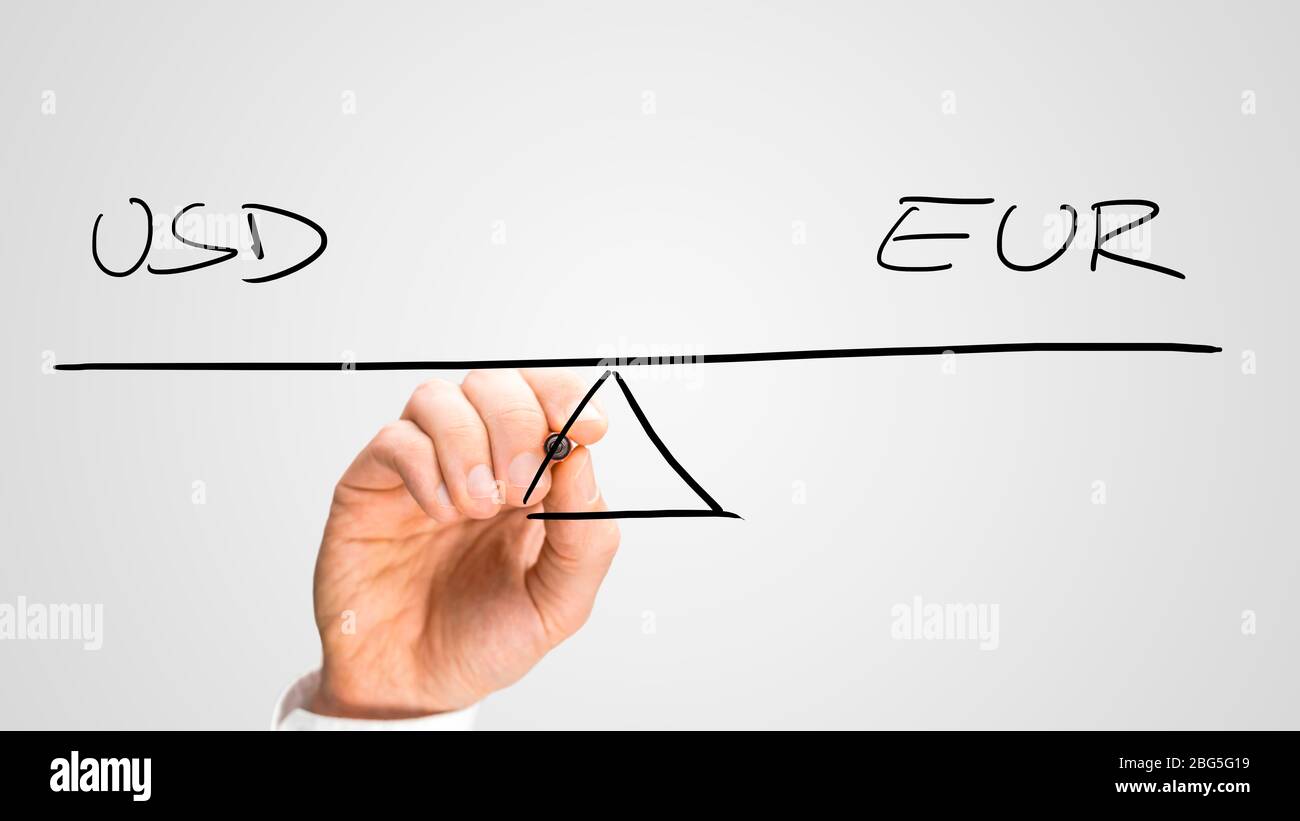 Conceptual image of the hand of a man drawing a seesaw in equilibrium with the text EUR - USD ...