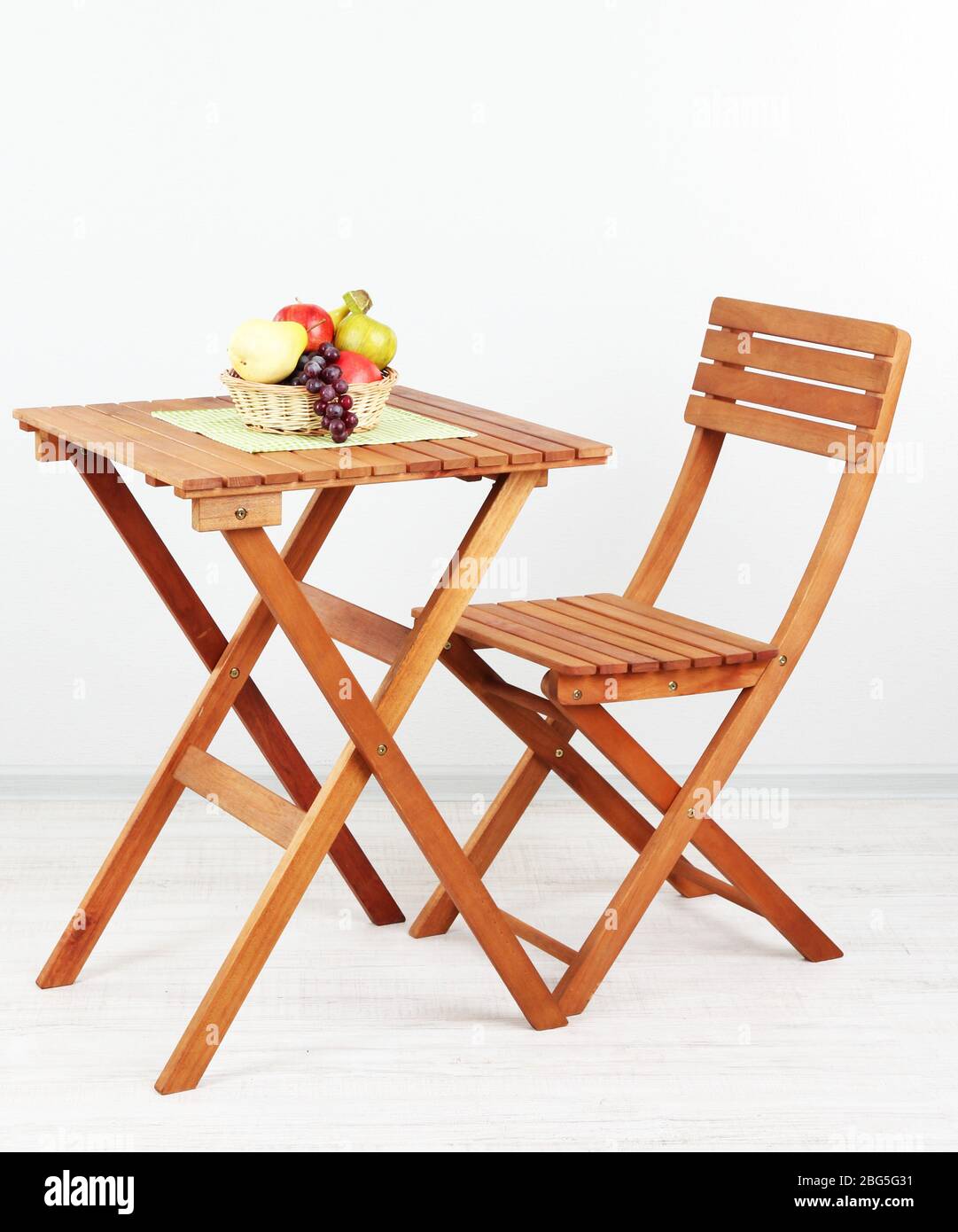 Wooden table with fruit in room Stock Photo - Alamy