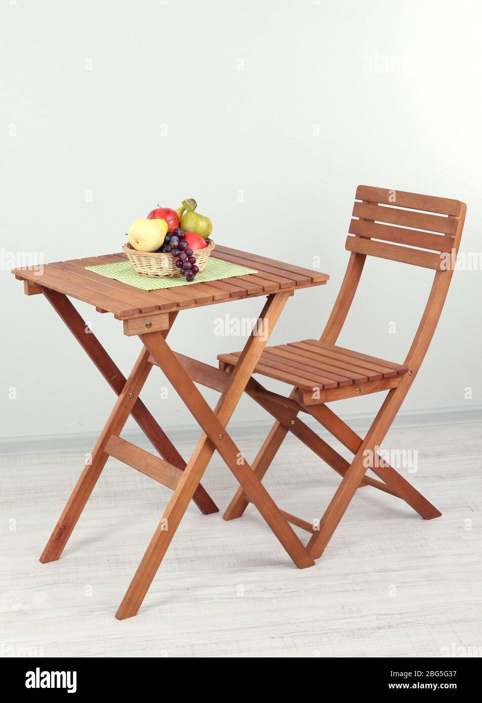 Wooden table with fruit in room Stock Photo - Alamy