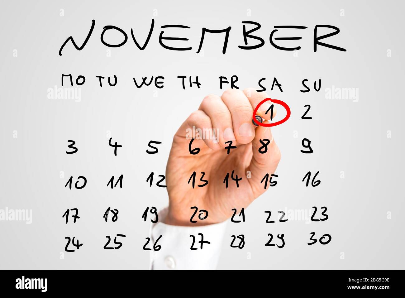 Man ringing the date of 1st November for All Saints Day with a red ...