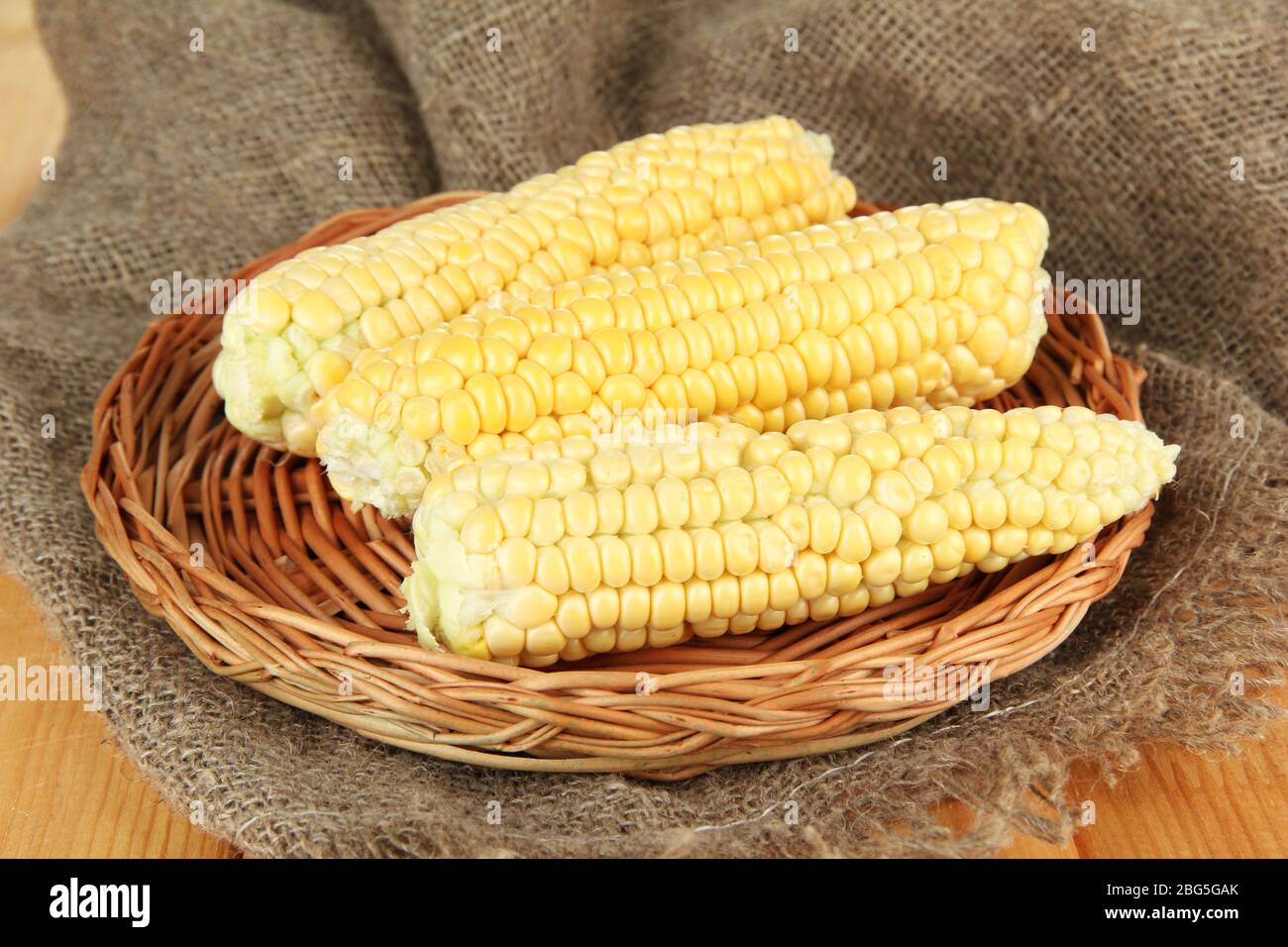Fresh corn on wicker mat, on sackcloth background Stock Photo - Alamy