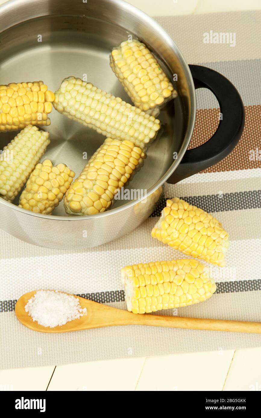 Boiled corn in pan, on wooden table, on wooden background Stock Photo ...