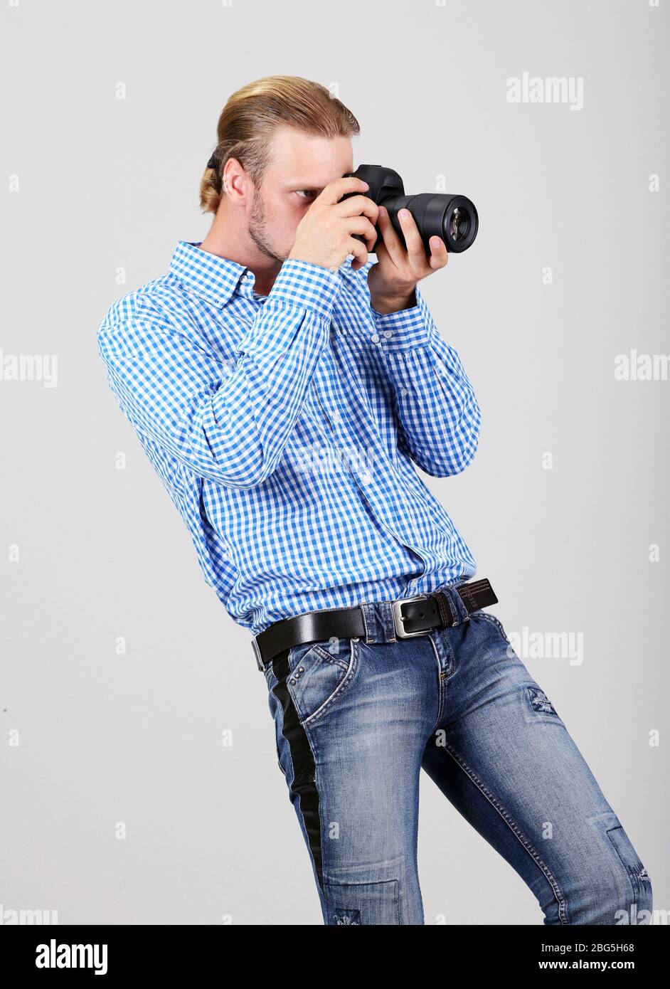 Handsome photographer with camera, on gray background Stock Photo - Alamy