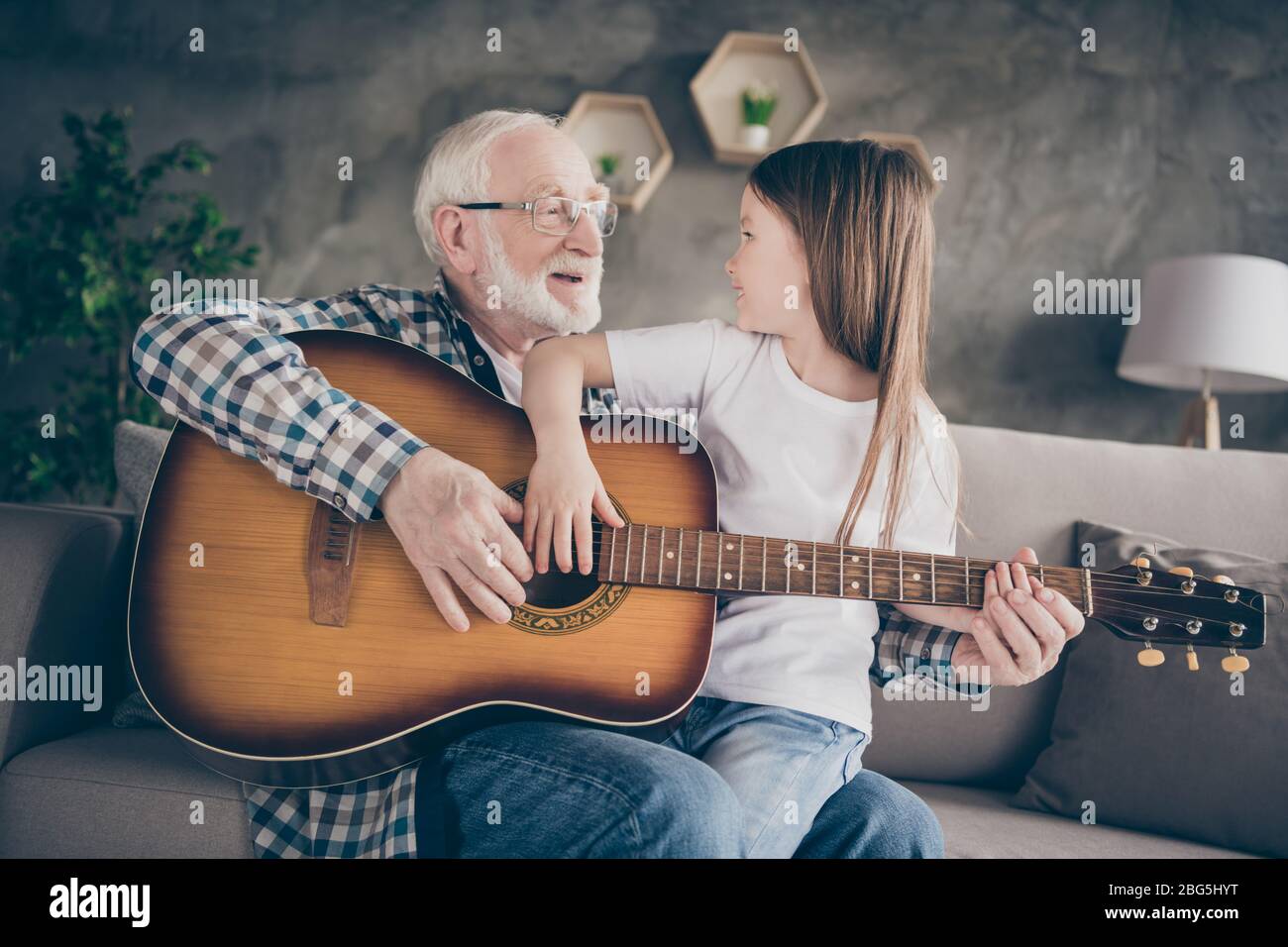 Photo of aged old grandpa little pretty granddaughter sitting comfy ...