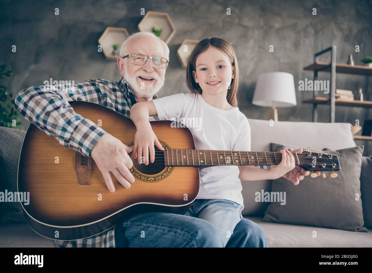 Photo of funny aged old grandpa little pretty granddaughter holding ...