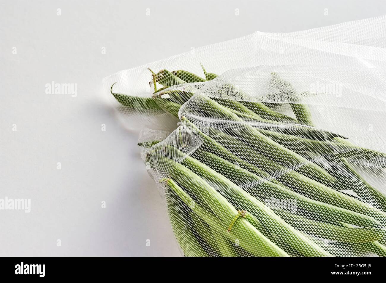 Green beans in sustainable grocery mesh bag. Vegetables in reusable eco ...