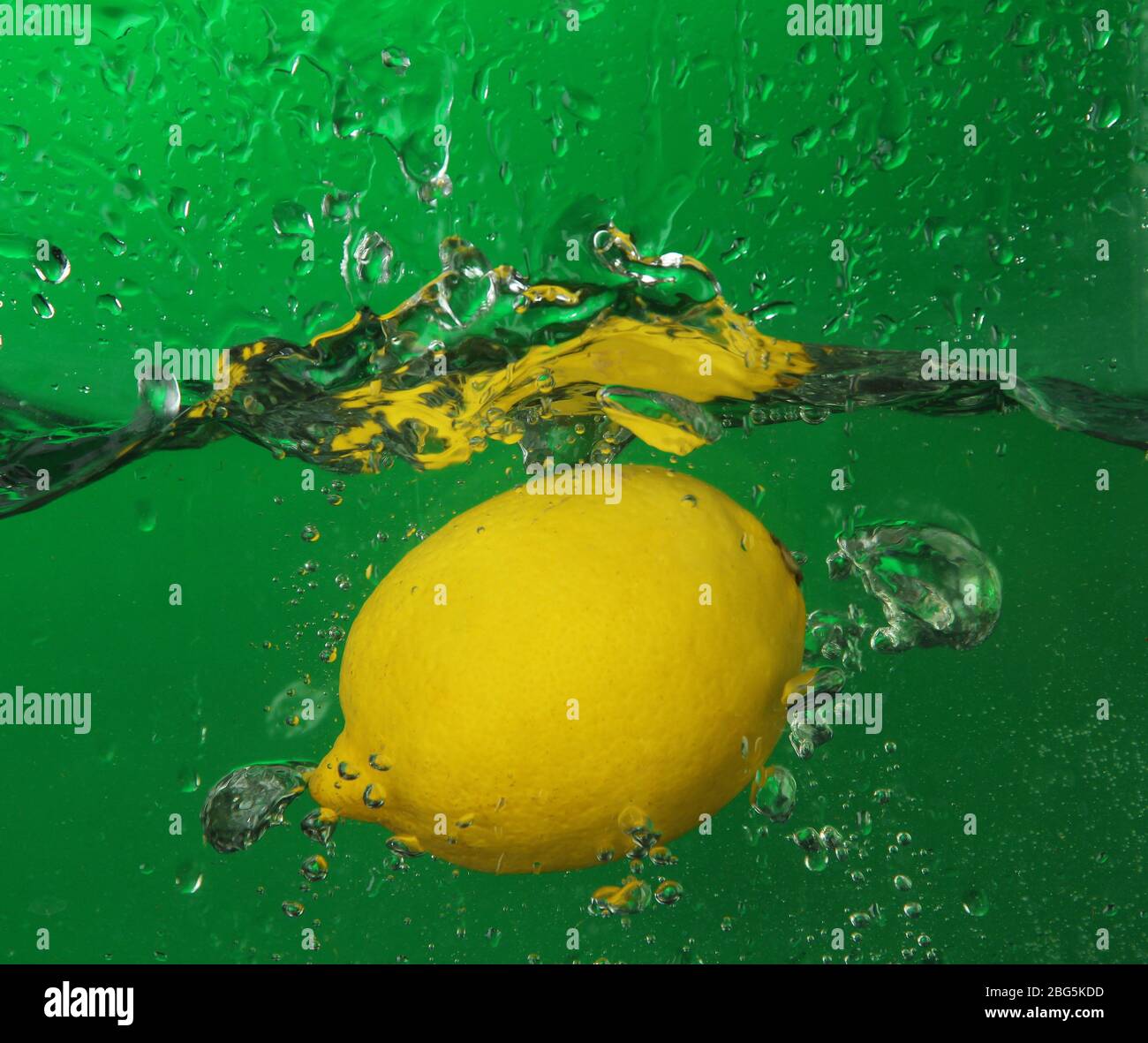 Juicy lemon under water, on green background Stock Photo - Alamy