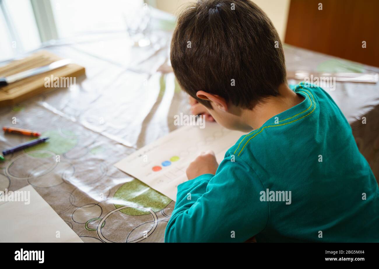 child drawing with crayons on paper or doing homework from home Stock ...