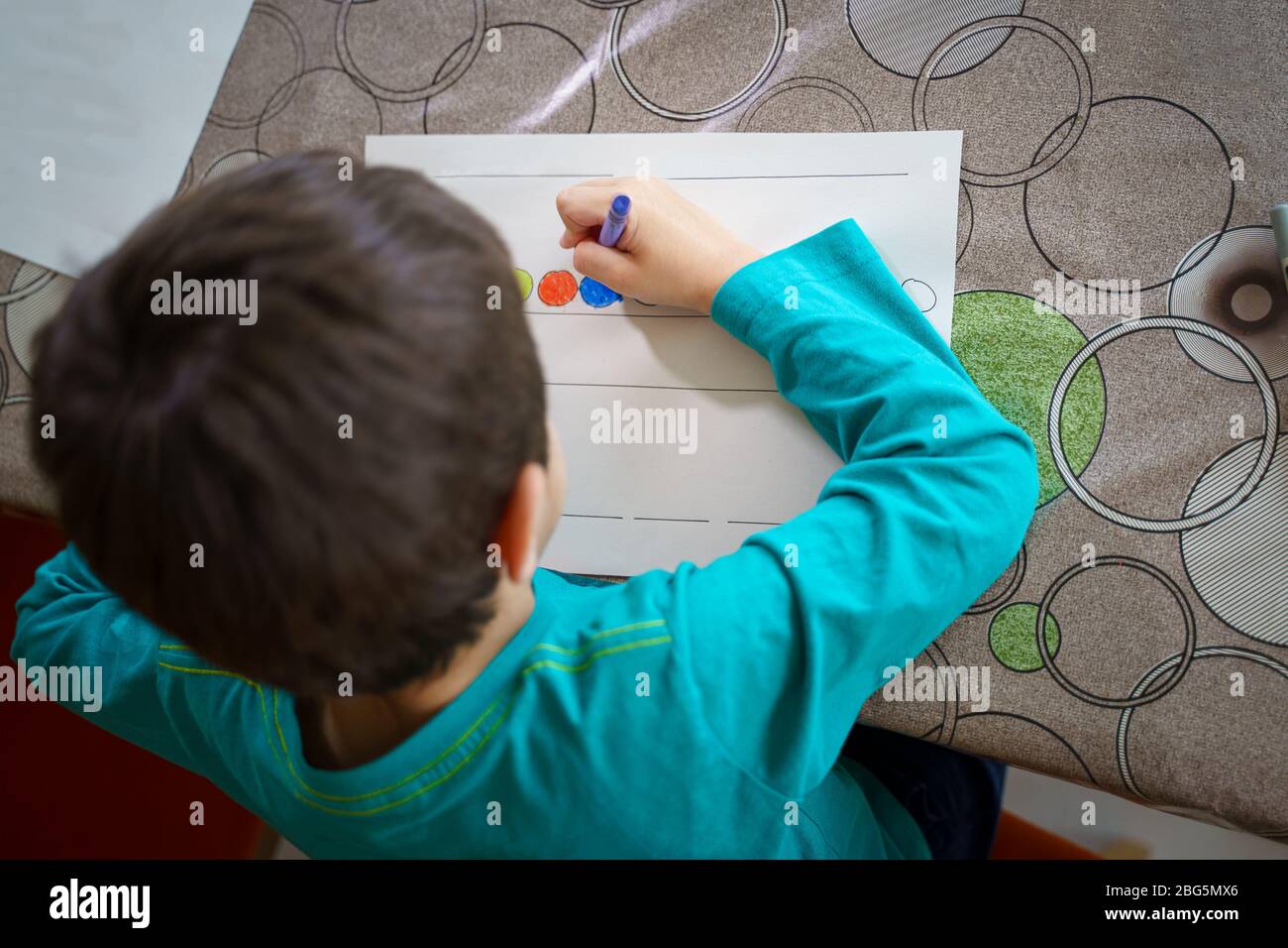 child drawing with crayons on paper or doing homework from home Stock ...