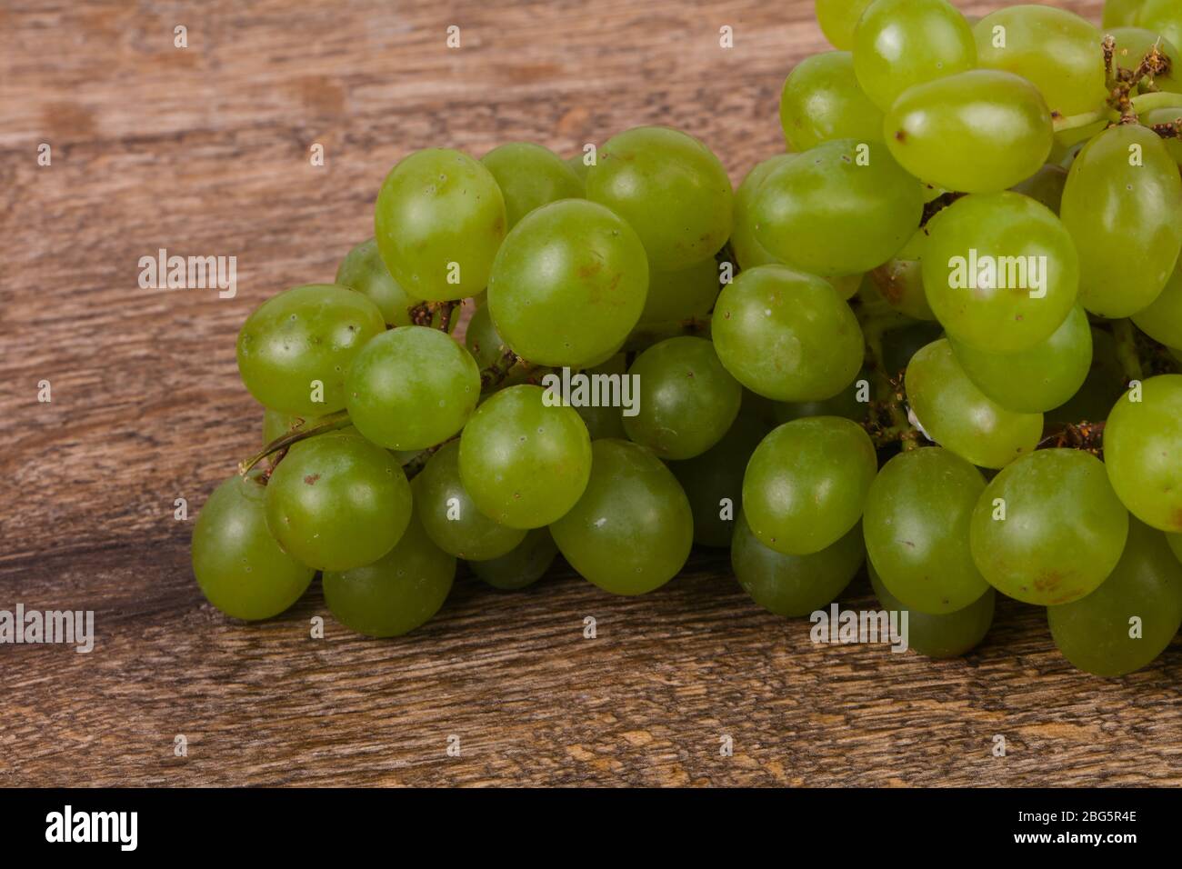 Sweet green grape branch over background Stock Photo - Alamy