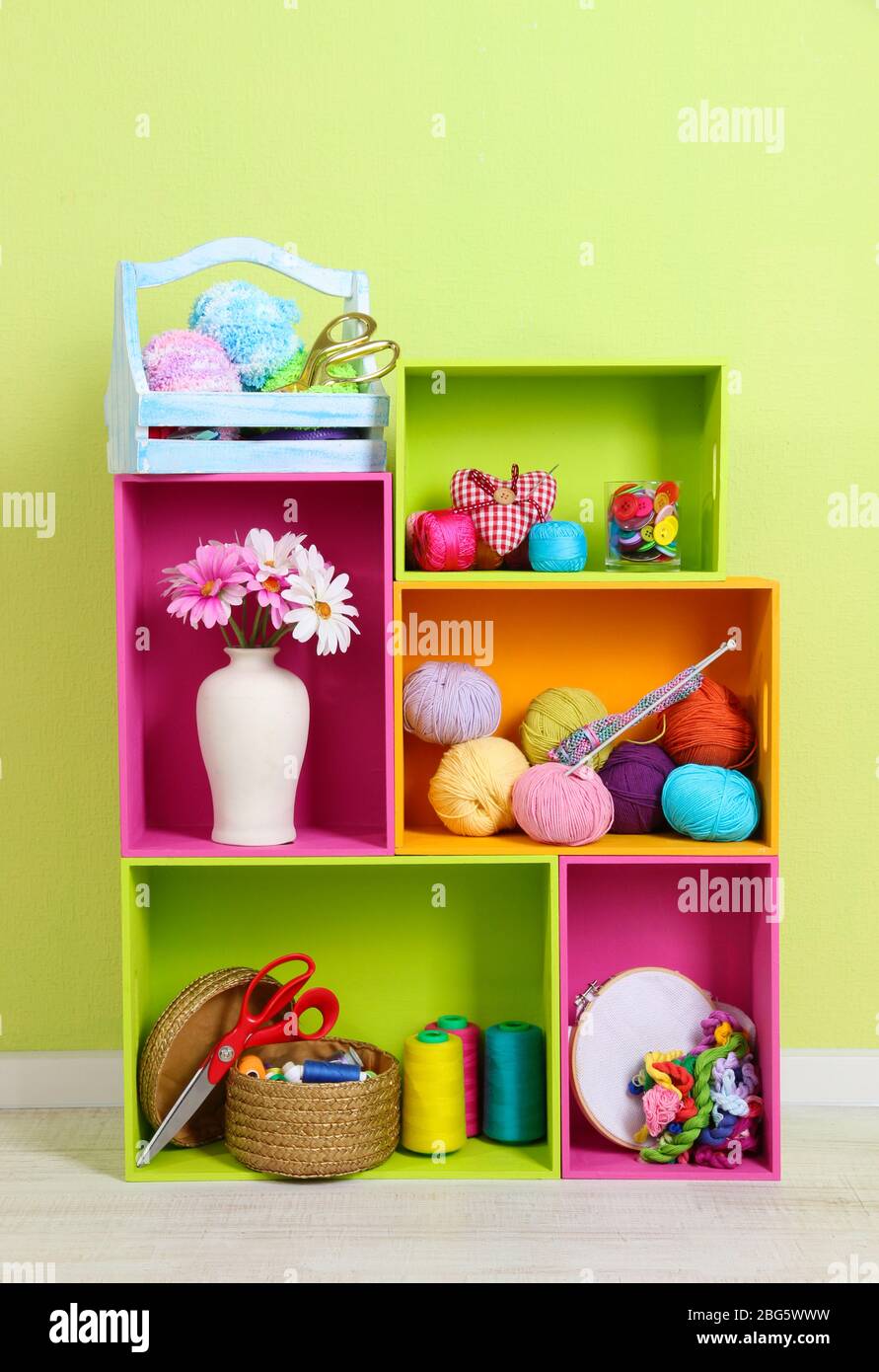 Colorful shelves of different colors with utensils on wall background ...