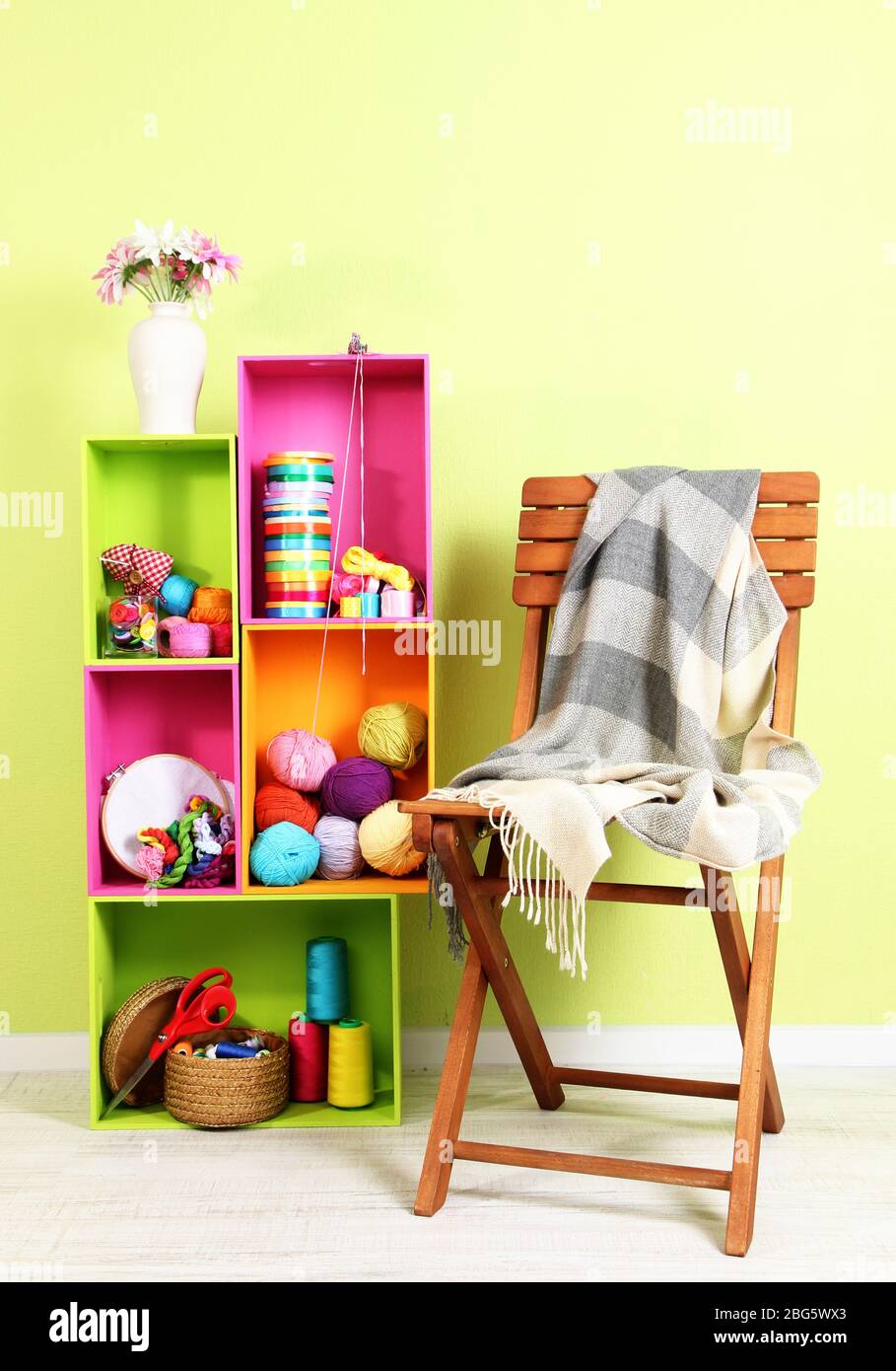 Colorful shelves of different colors with utensils near chair with ...