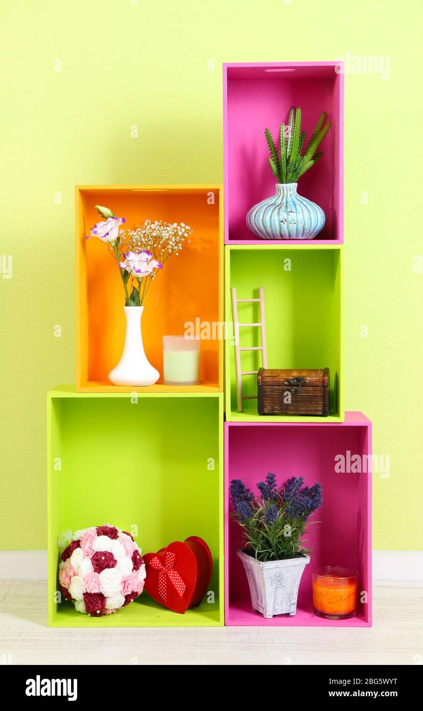 Shelves of different bright colors with decorative addition on wall ...