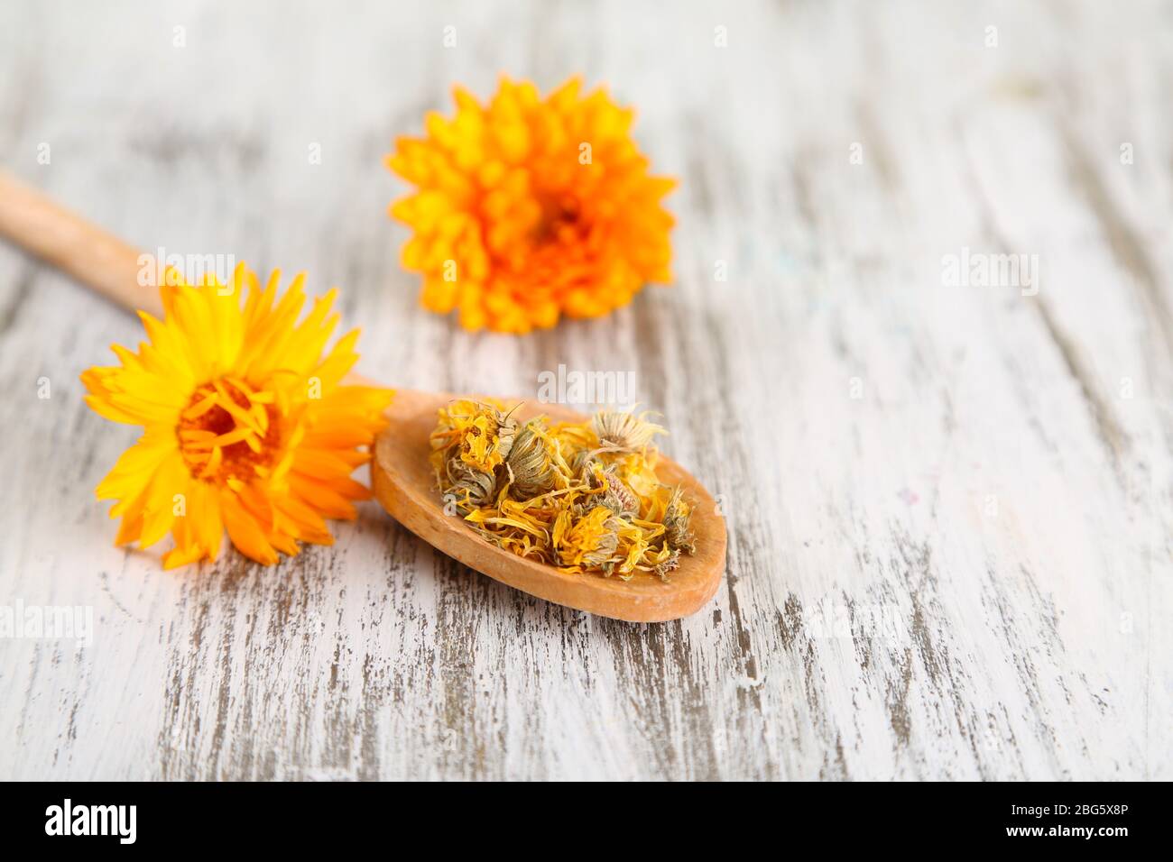 Fresh and dried calendula flowers on wooden background Stock Photo - Alamy