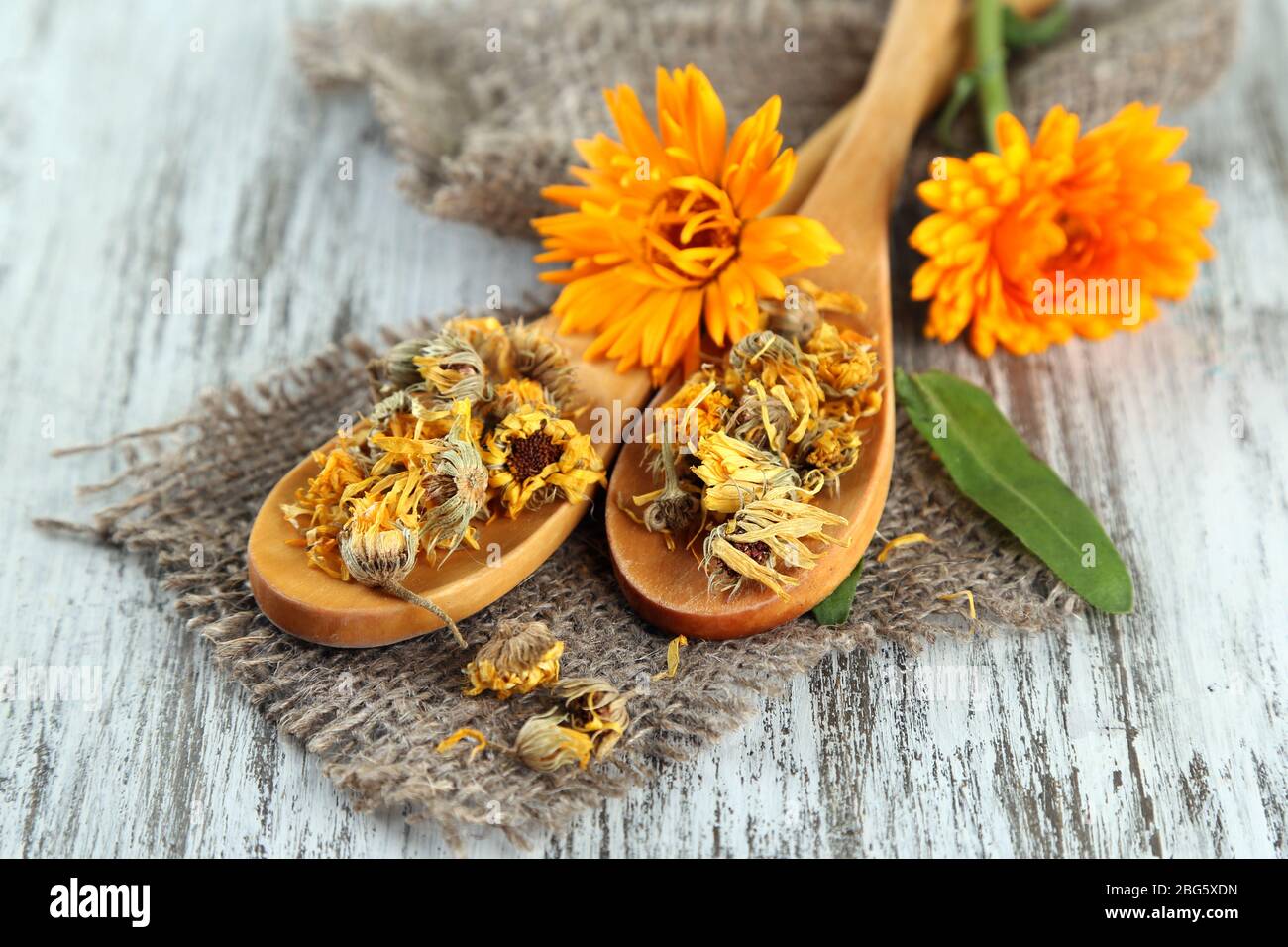 Fresh and dried calendula flowers on wooden background Stock Photo - Alamy